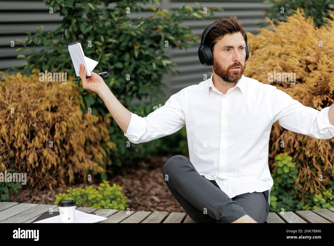 Excited businessman throwing up hands with notebook, while working ...