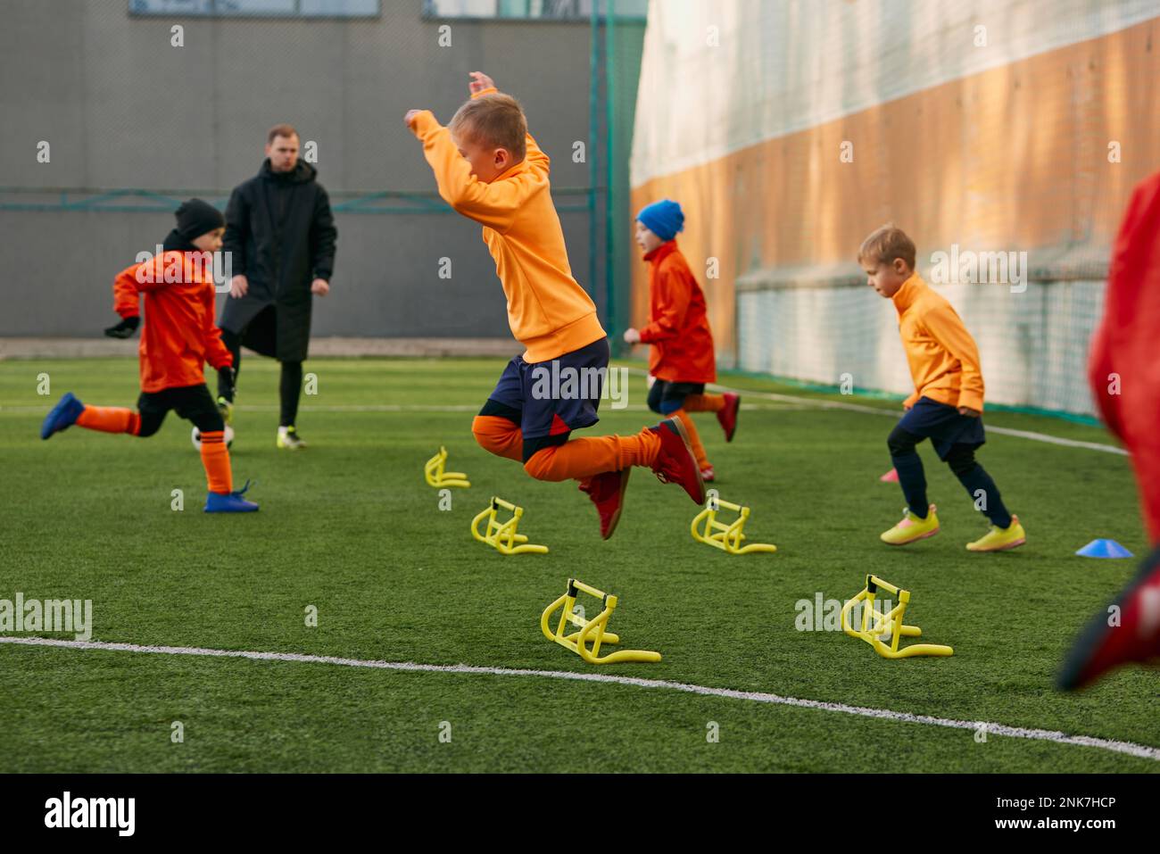 Boys, children, football players doing exercises, warming up before ...