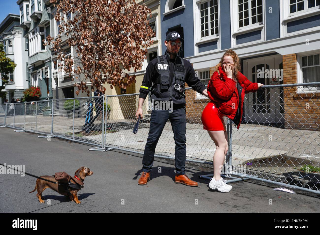 A woman laughs after getting swatted on her behind by a man in costume ...
