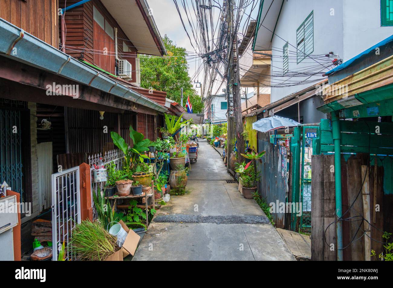 Narrow city street at Bangkok city, Thailand. Small street with houses ...