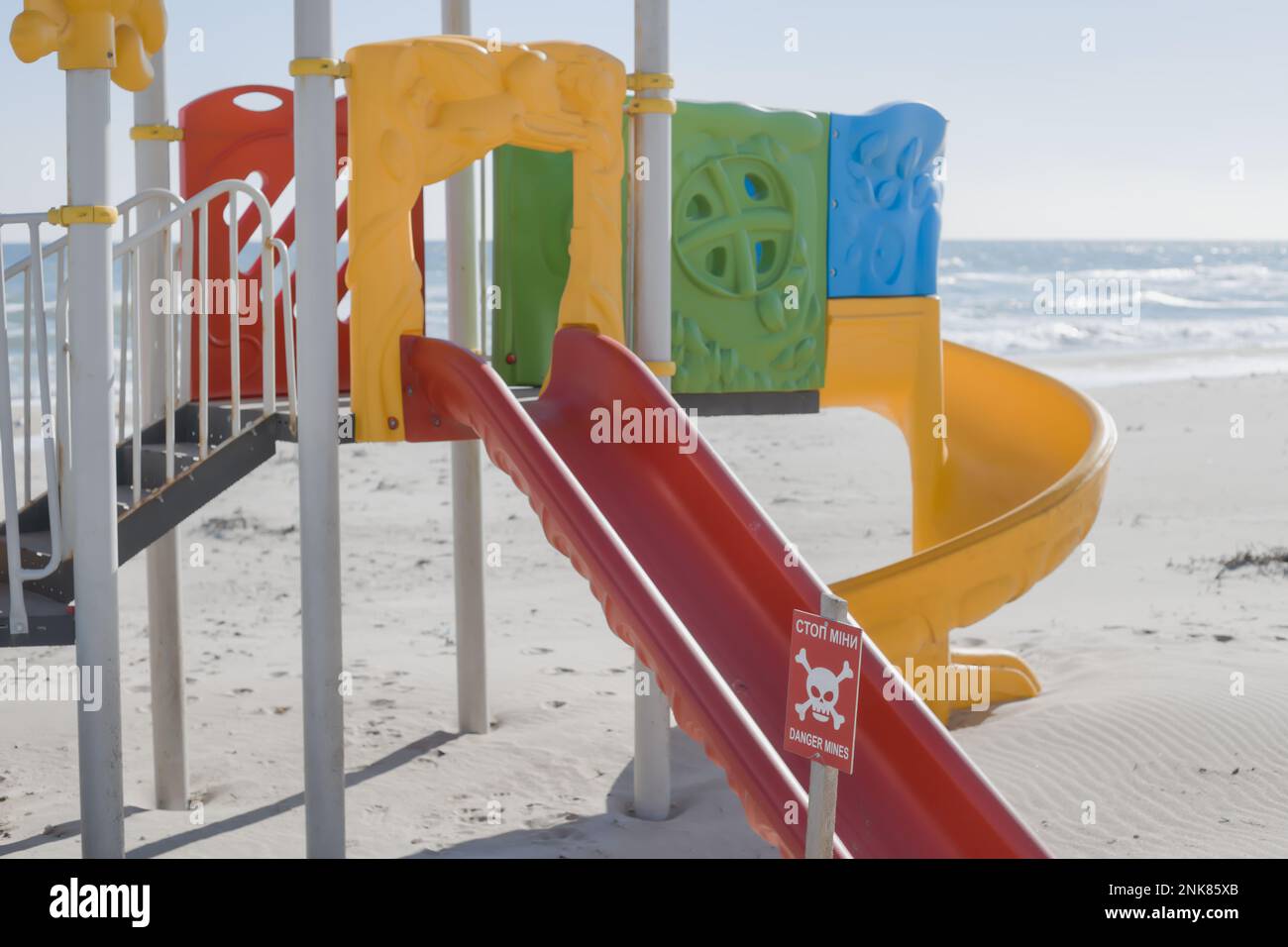 An empty beach, an empty playground, a sign with the inscription ...
