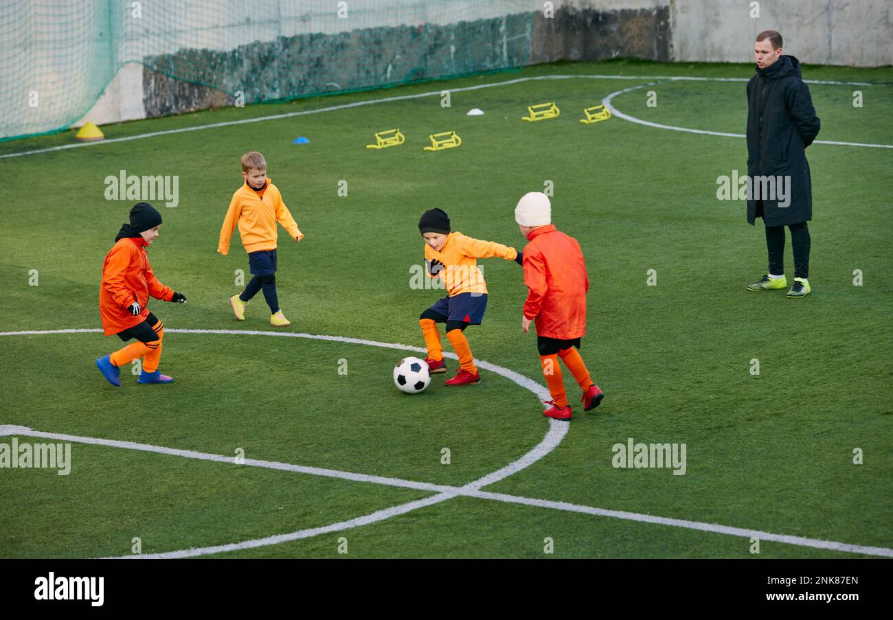 Group of boys, children, football players in uniform in motion, playing ...