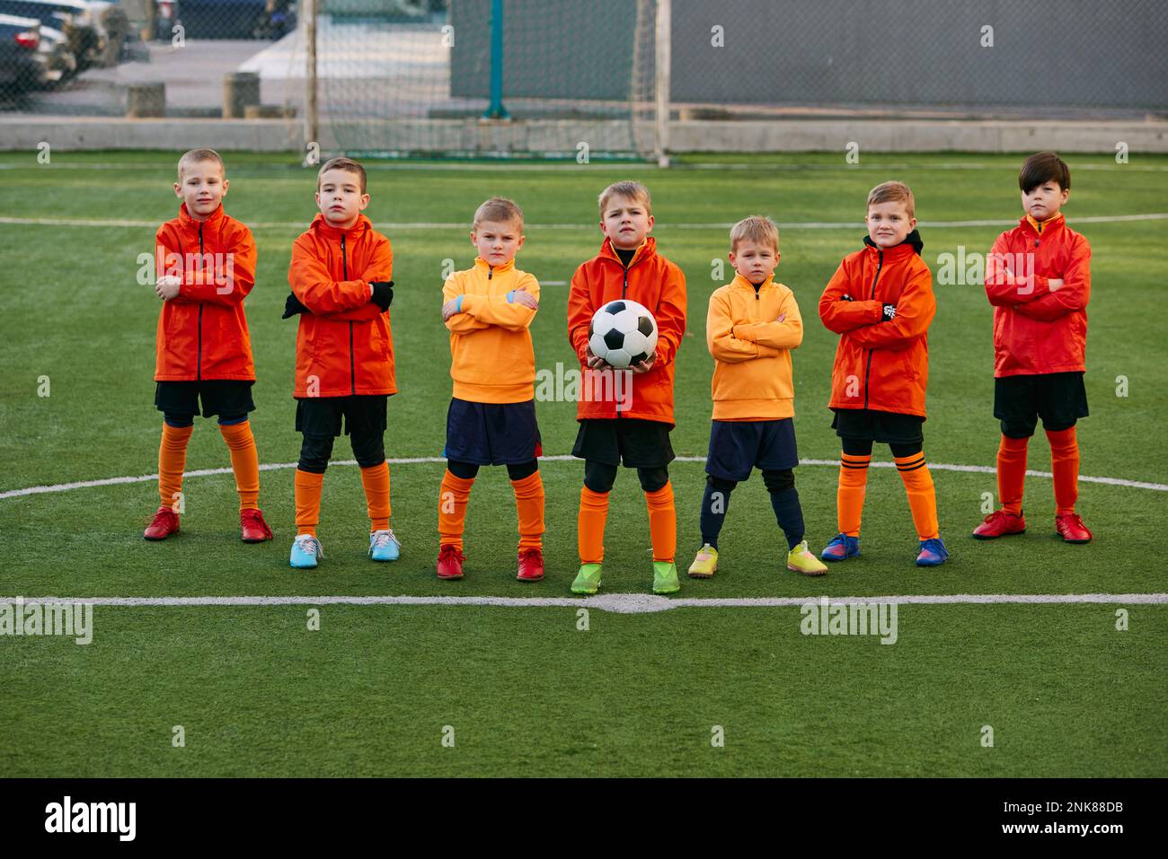 Group of boys, children, football players in uniform standing in a line ...