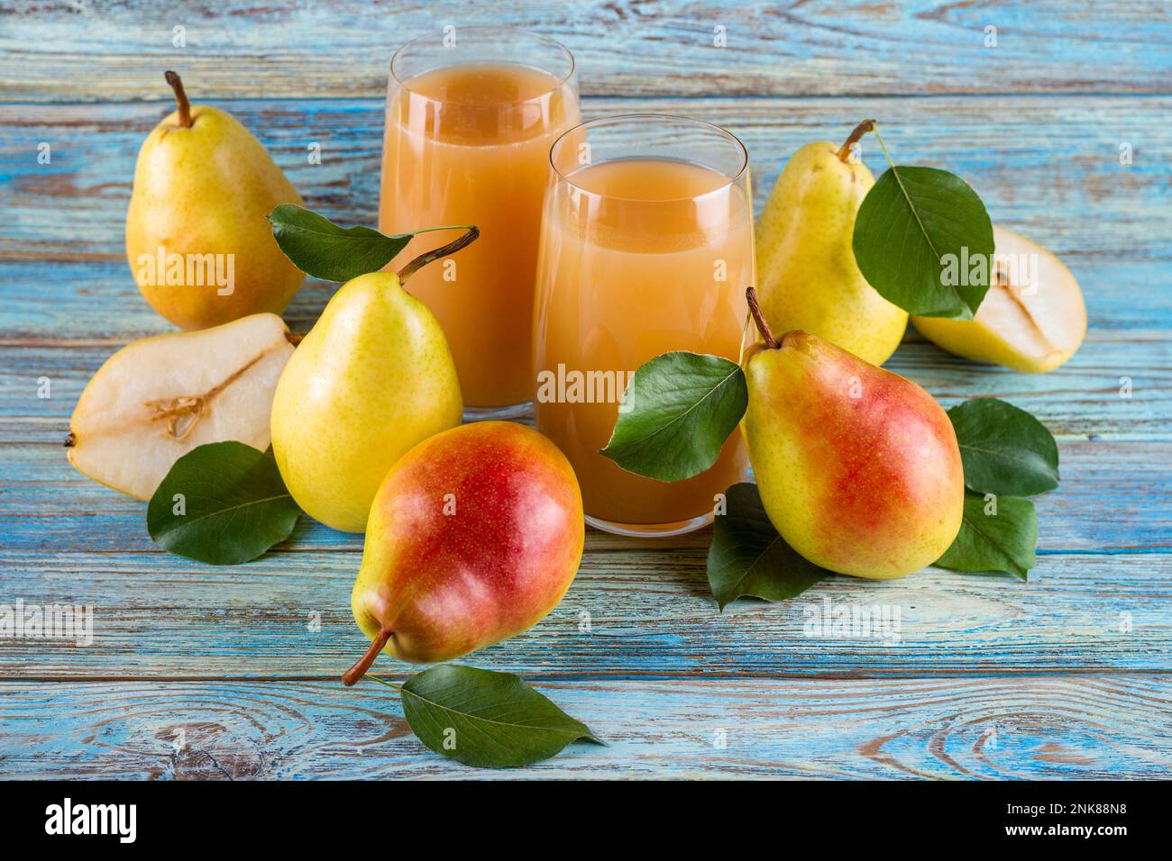 Fresh organic farm pear juice in glass with raw whole and sliced pears ...