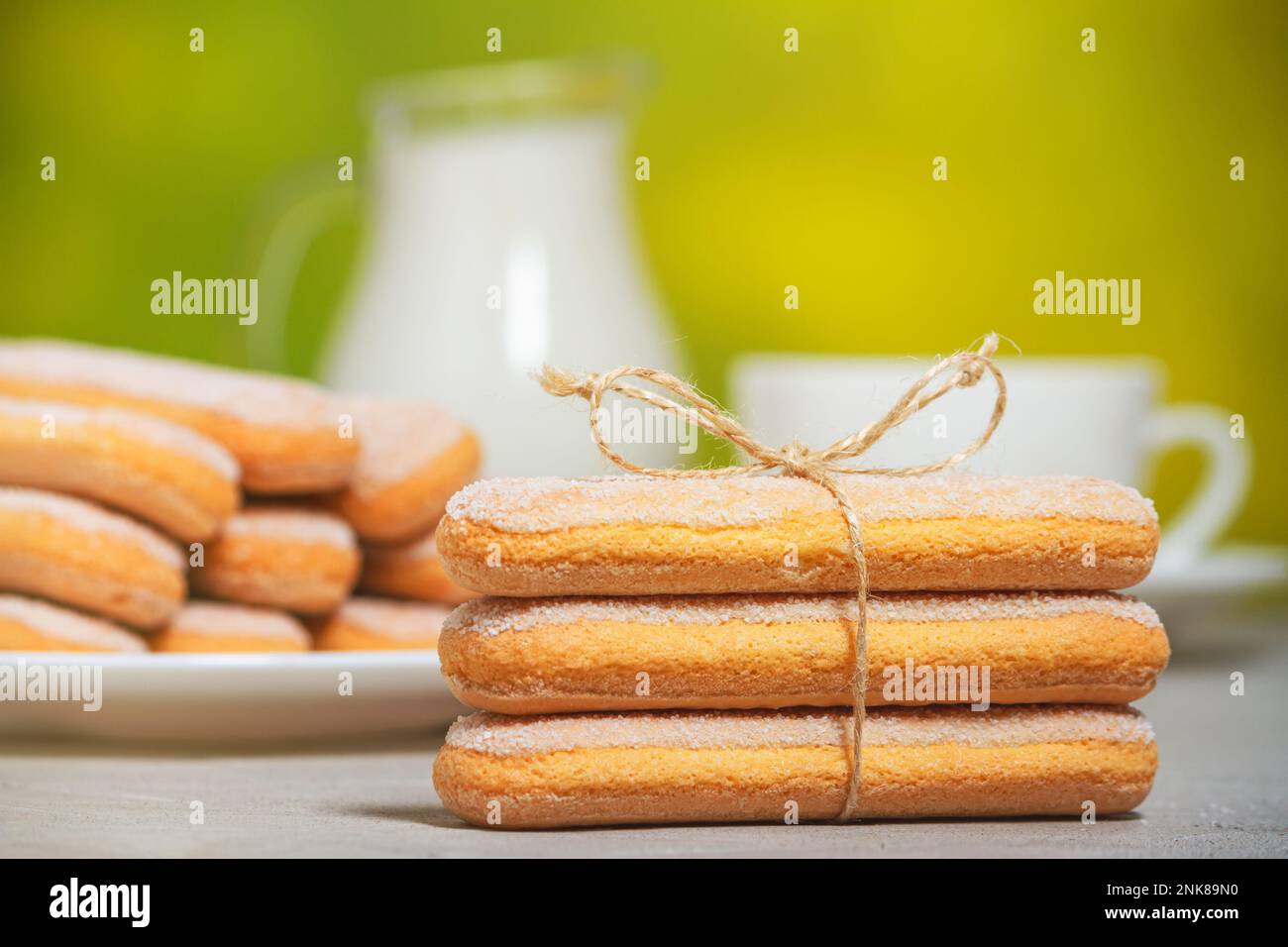 Italian savoiardi biscuits or ladyfingers cookies on a plate and in a ...