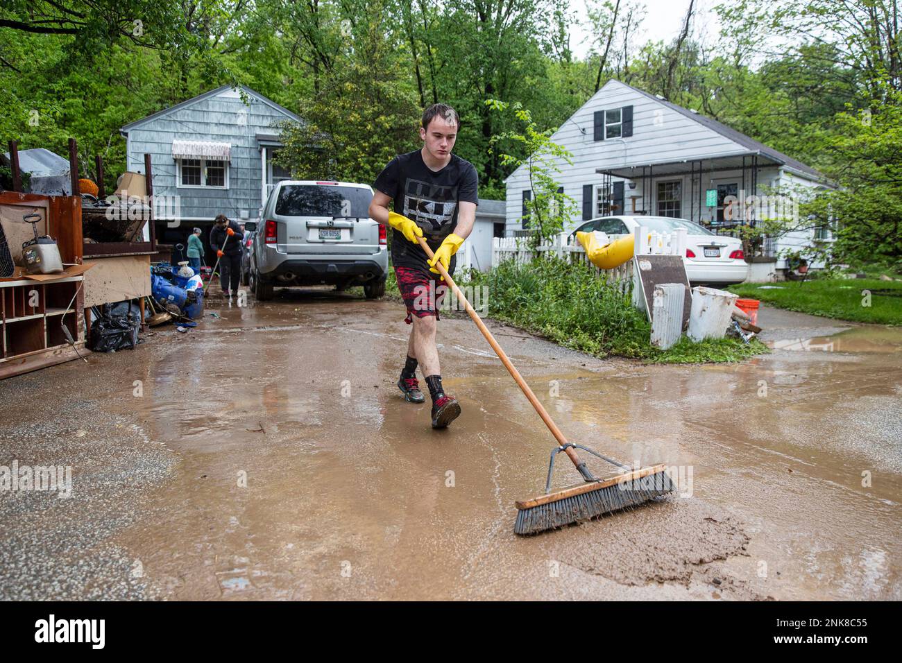 Reid Pennington sweeps away mud as area residents affected by Friday's ...
