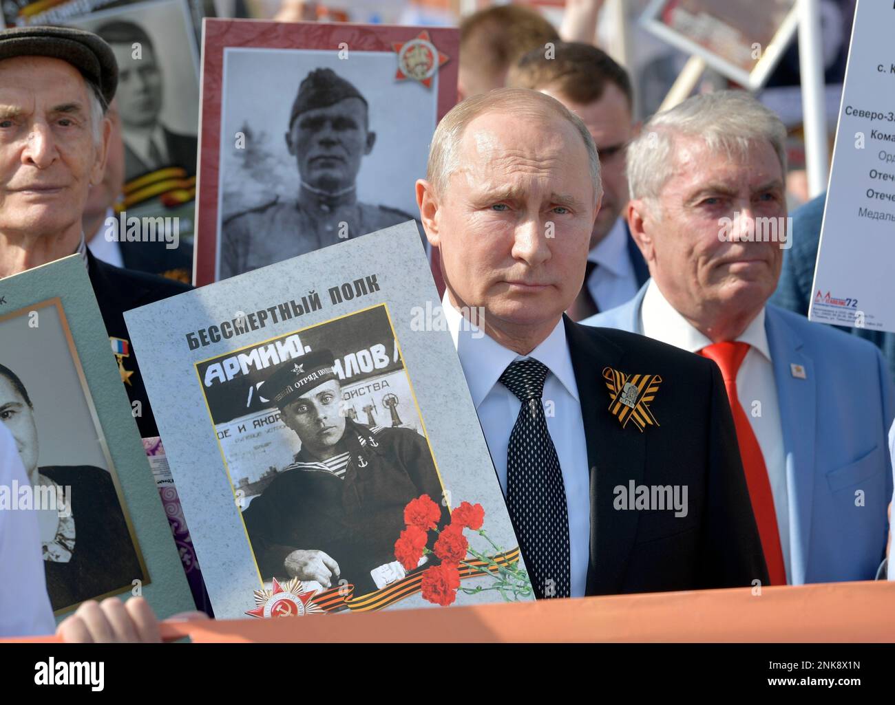 FILE - Russian President Vladimir Putin, center, holds a portrait of ...