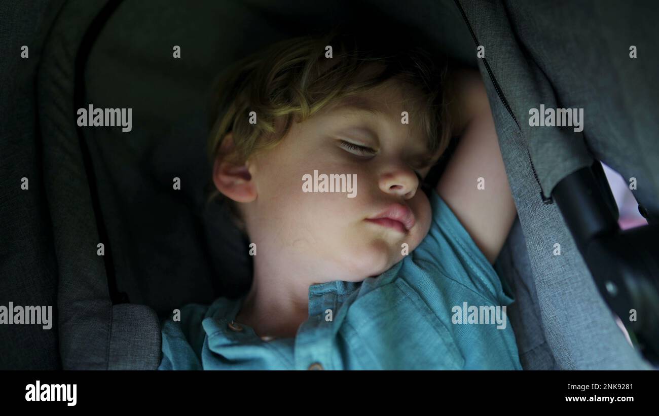 One cute child sleeping laid in stroller. Adorable kid napping having ...