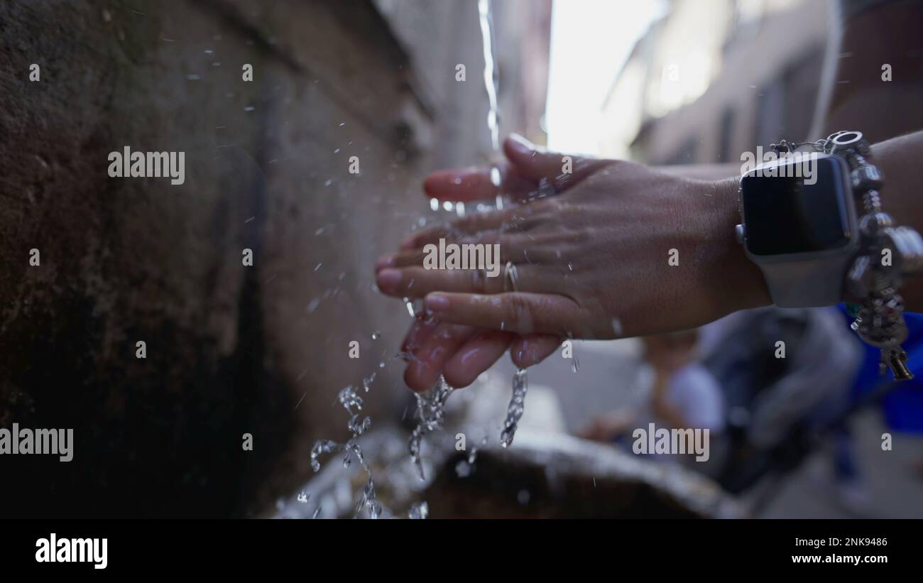 Washing hands in public water fountain in slow motion with droplets ...