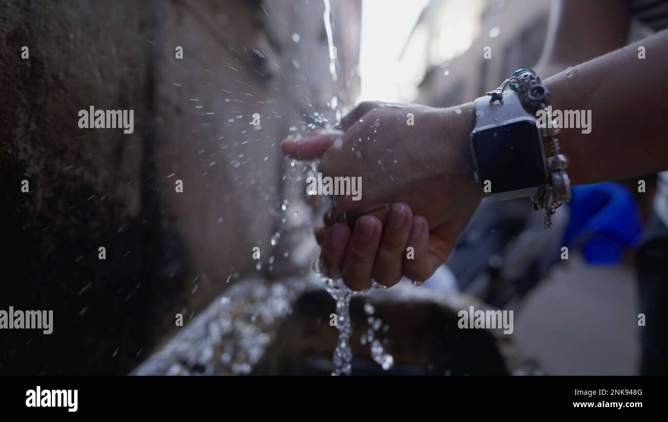 Washing hands in public water fountain in slow motion with droplets ...