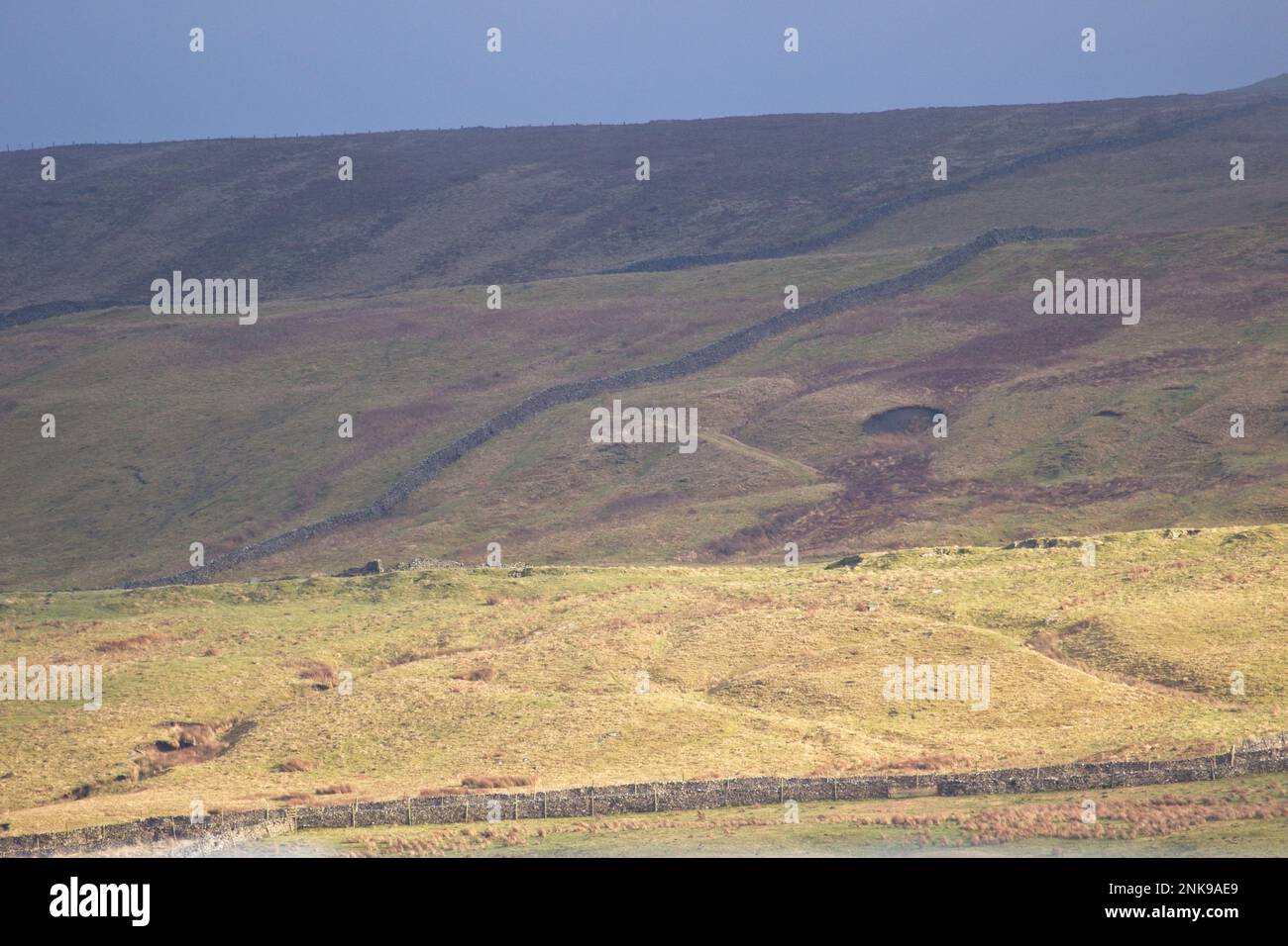 Sun lights up part of the hillside of a North Yorkshire landscape on a ...
