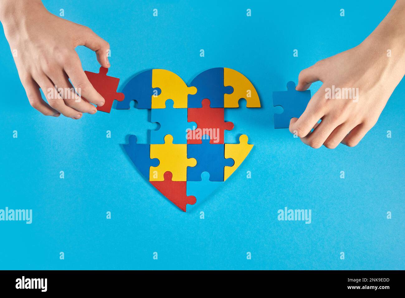Autistic boy hands holding jigsaw puzzle heart shape. World Autism ...
