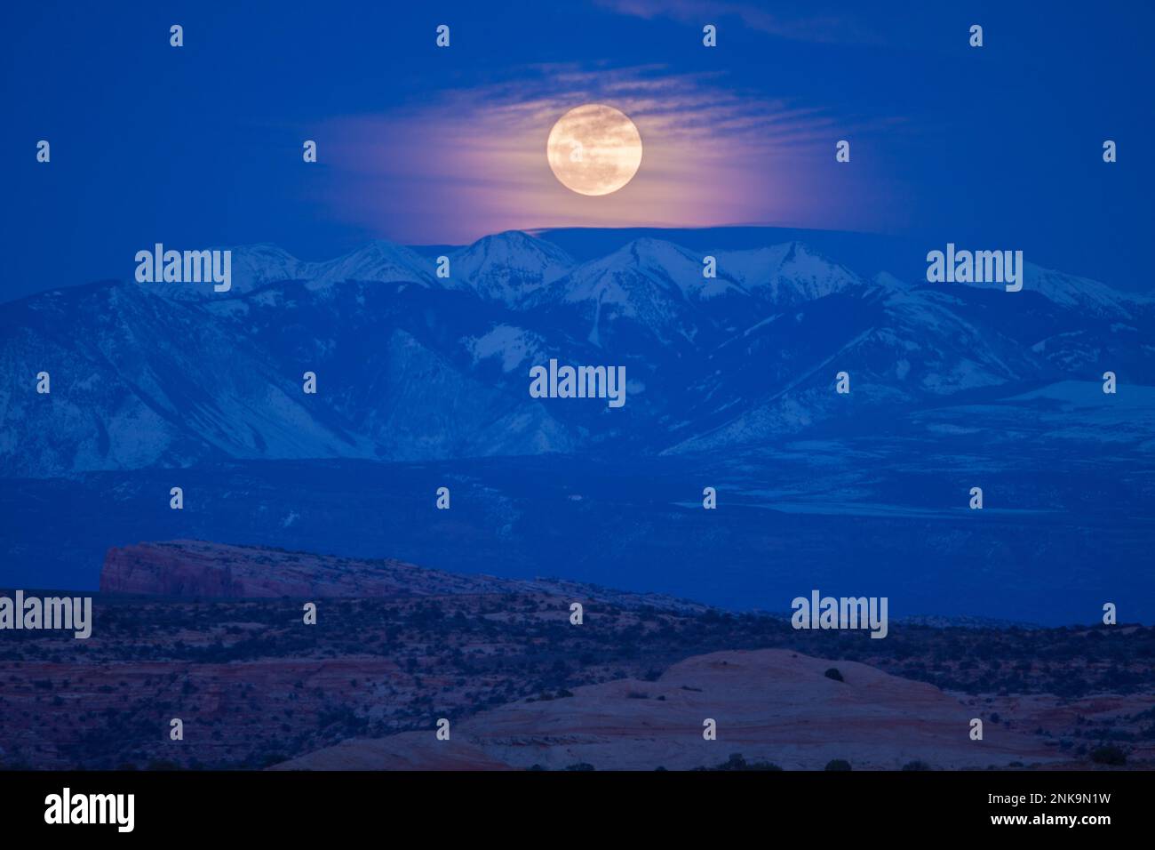 Full moon rising over the snow-capped La Sal Mountains at evening ...