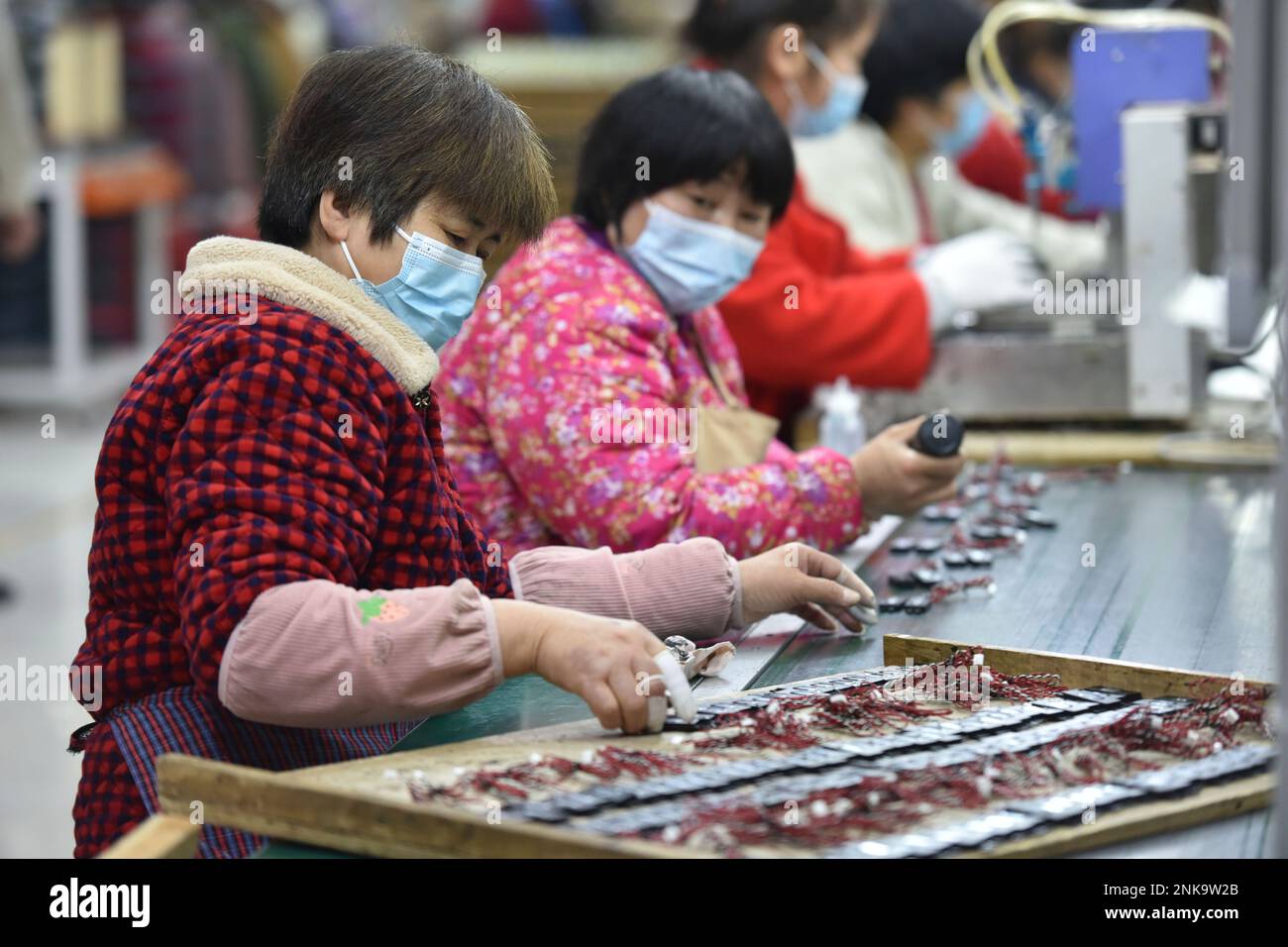 Workers assemble speakers at an electronics factory in Linquan in ...