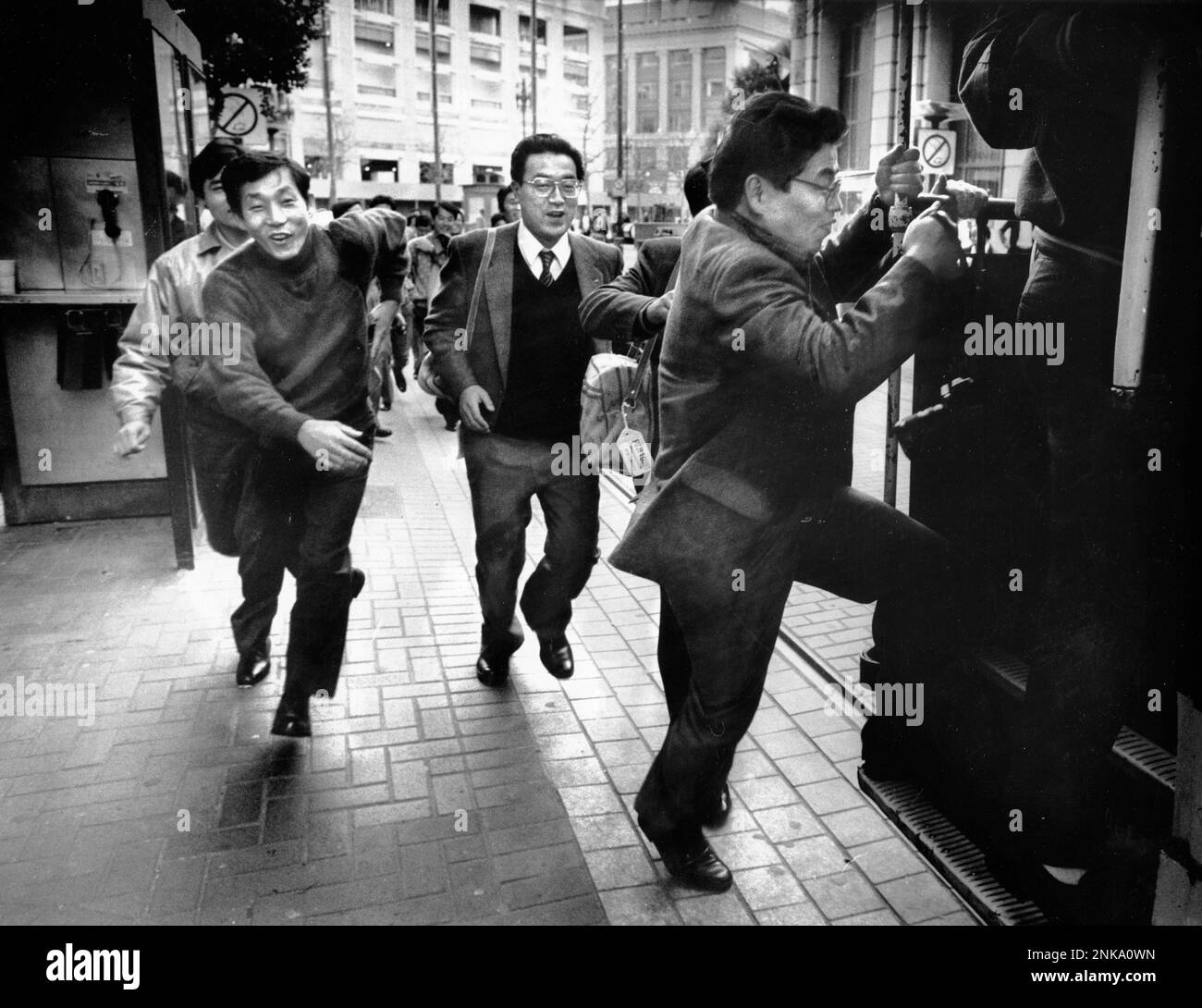 Three tourists rush to hop a cable car at the Powell Street turnaround ...
