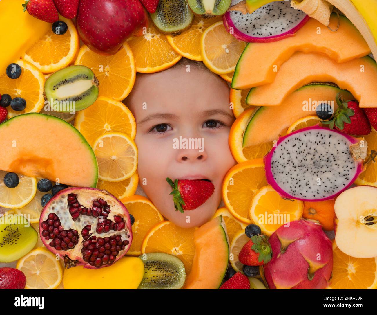 Strawberry in child mouth. Frutit and child face close up. Top view of ...