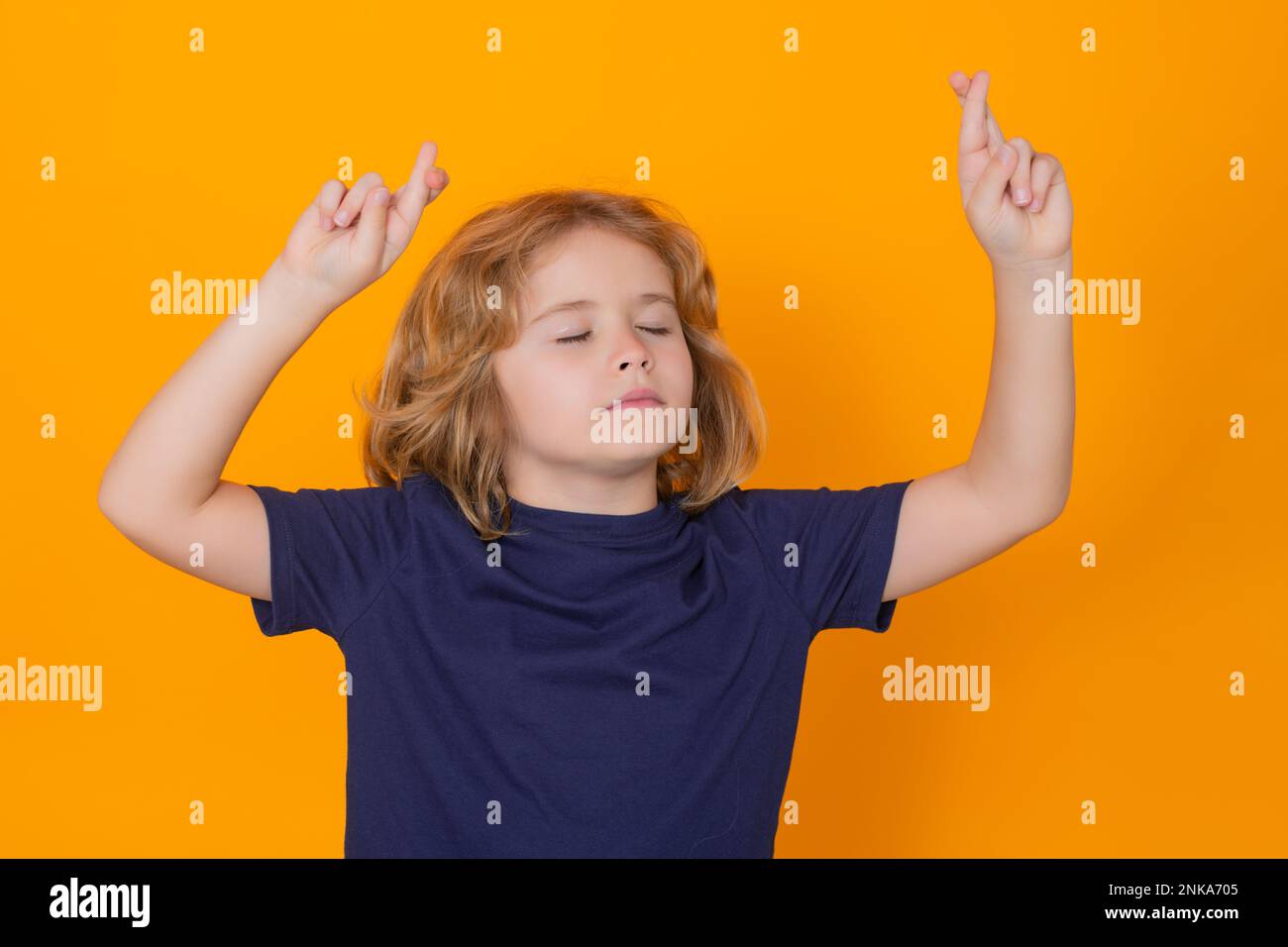 Kid crossed fingerson yellow isolated studio background. Child closed ...