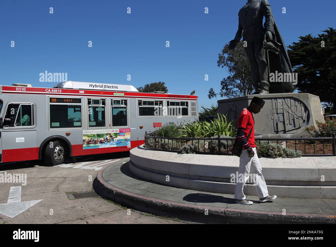 Haitian artist Claudel Casseus walks past a statue of Christopher ...