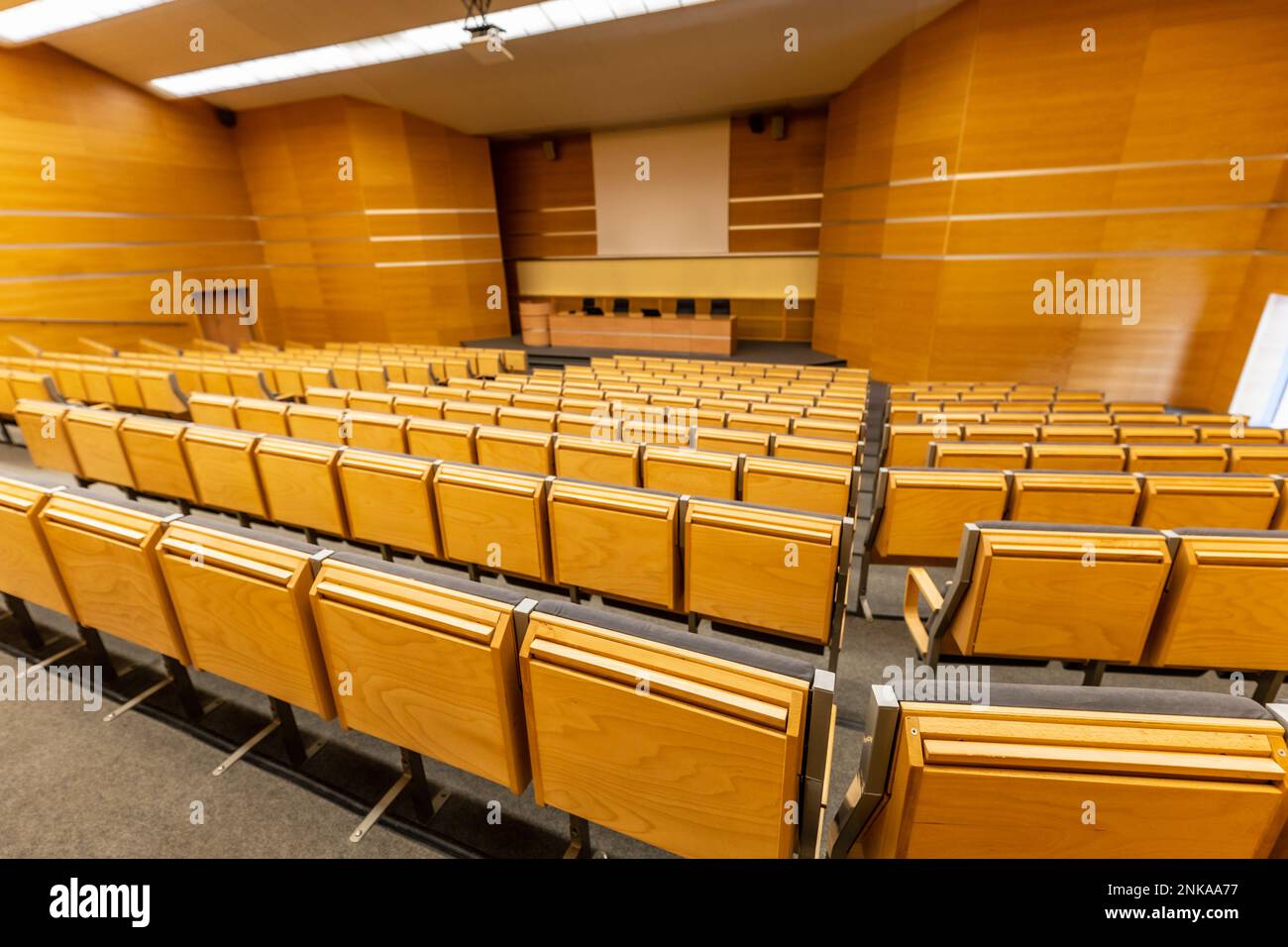 Interior of big conference hall full of gray folding chairs and wooden ...