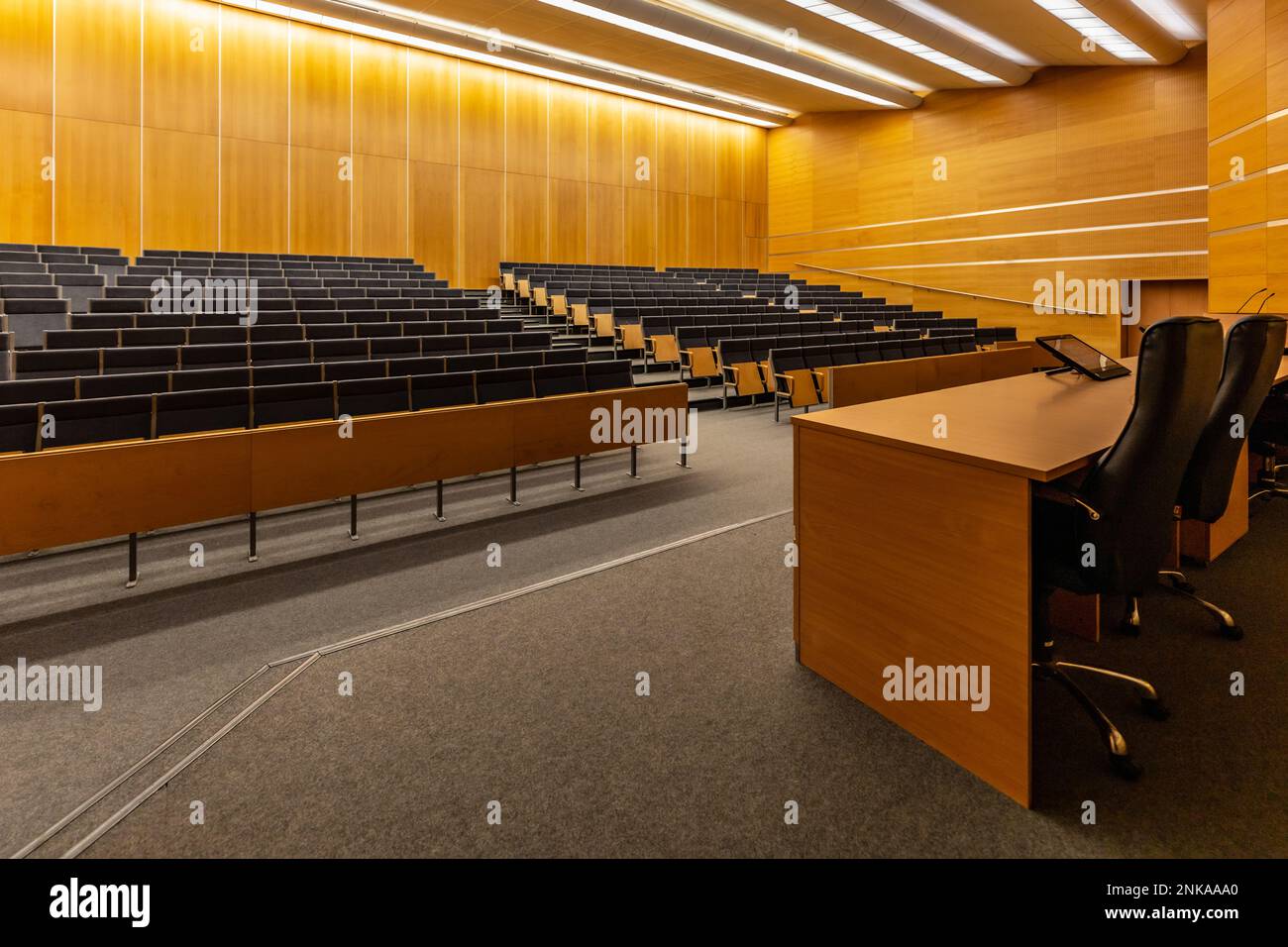 Interior of big conference hall full of gray folding chairs and wooden ...