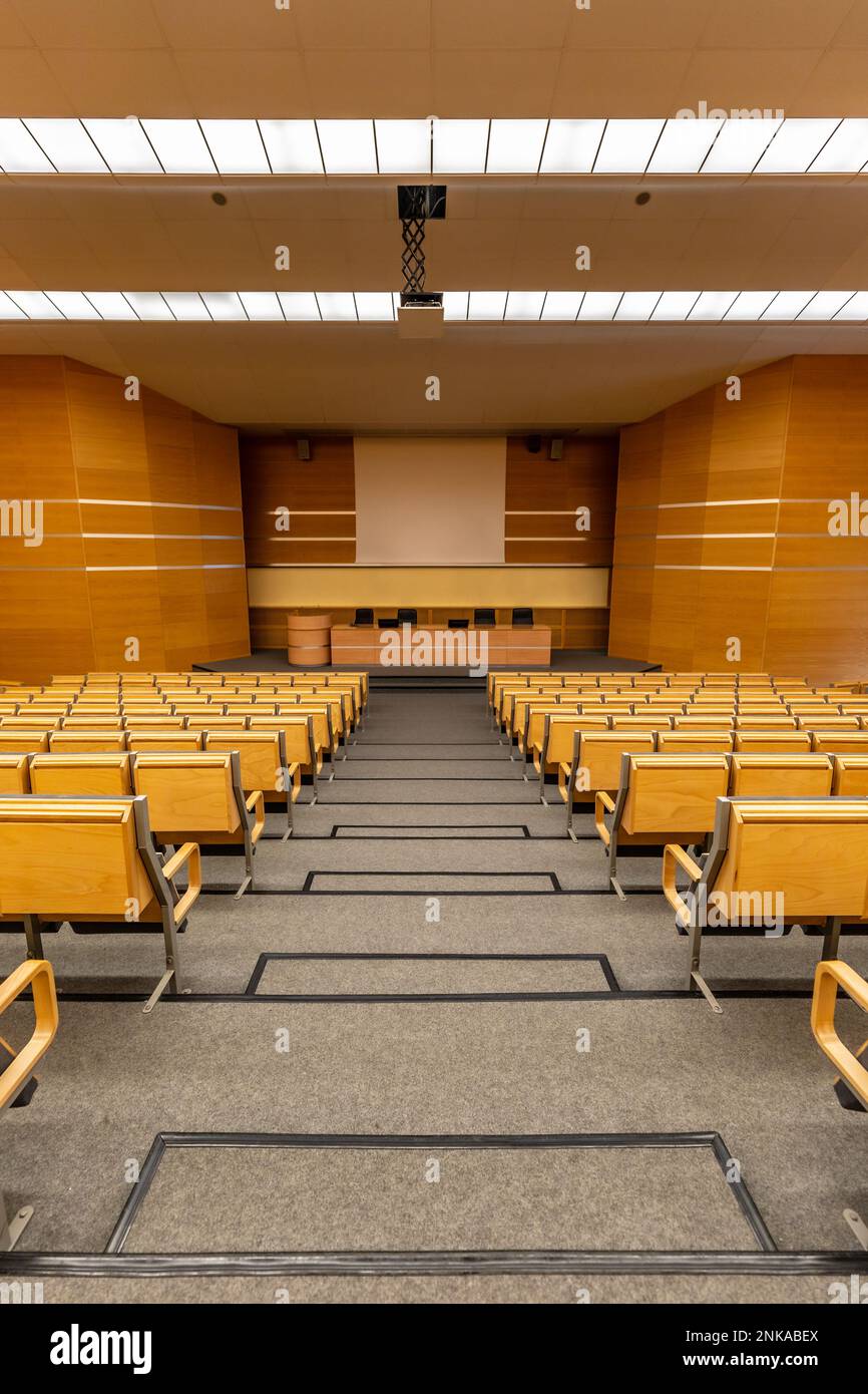 Interior of big conference hall full of gray folding chairs and wooden ...