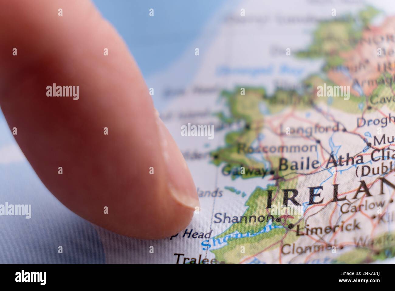 Finger pointing to Shannon, Ireland on colorful map with selective ...