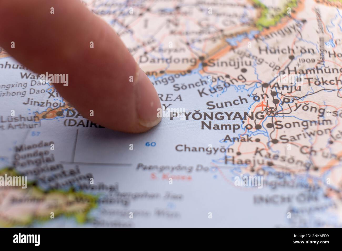 Finger pointing to Pyongyang, North Korea on detailed map with ...