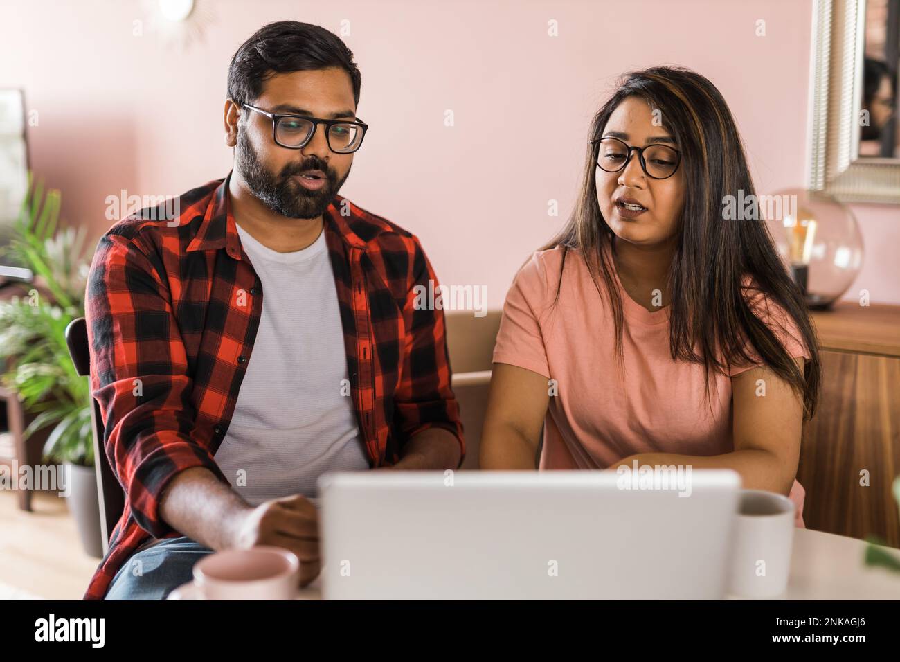 Happy indian family couple cuddle at desk make video call to friends ...