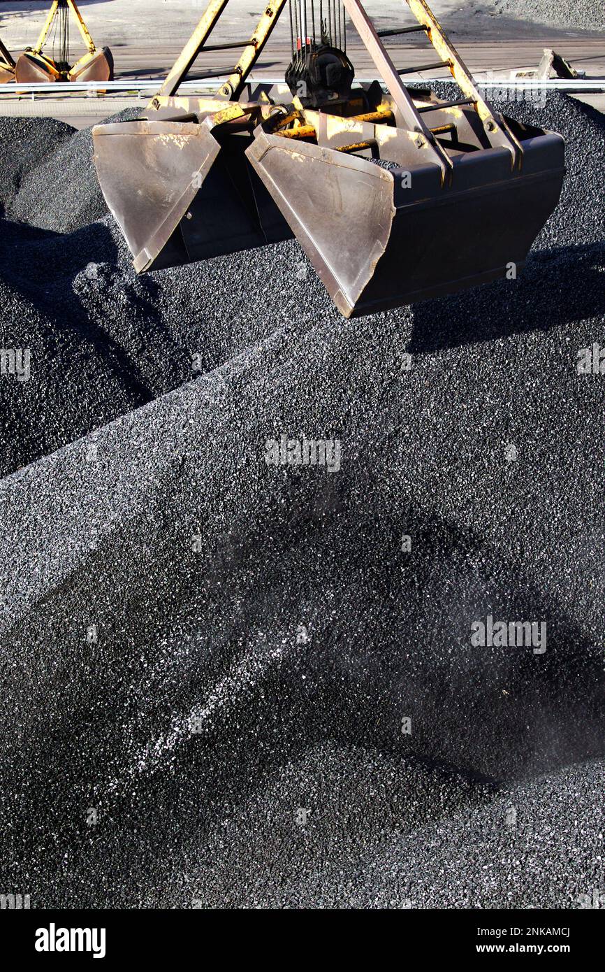 A port loader reloading coal from a heap at a cargo port Stock Photo ...