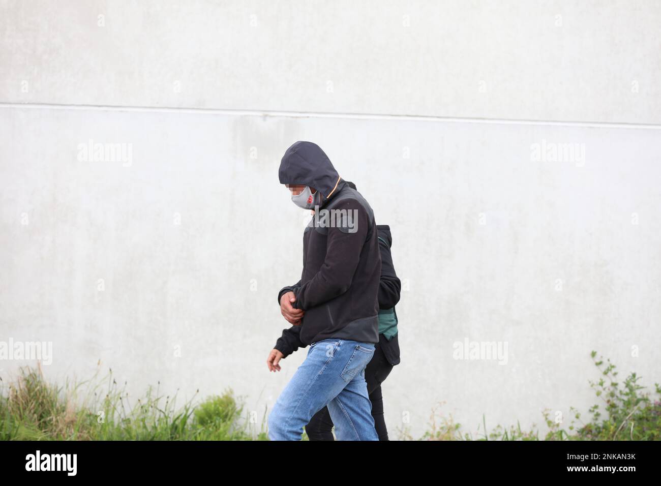 Police officers carry a detained person out of a building on the day ...