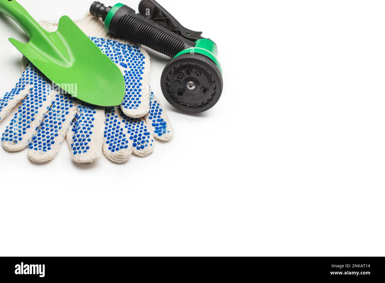 Plastic watering gun, a spade and garden gloves on a white background ...