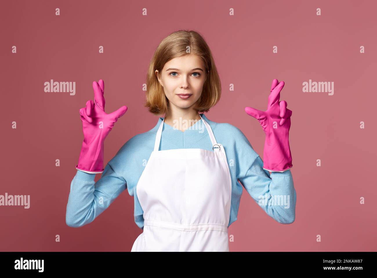 girl in rubber gloves with finger crossed gesture Stock Photo - Alamy