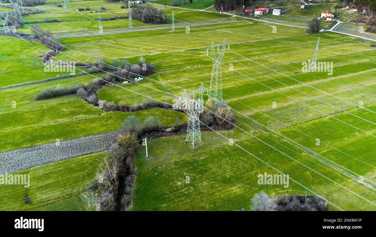 High voltage power transmission towers near a winding creek. Drone ...