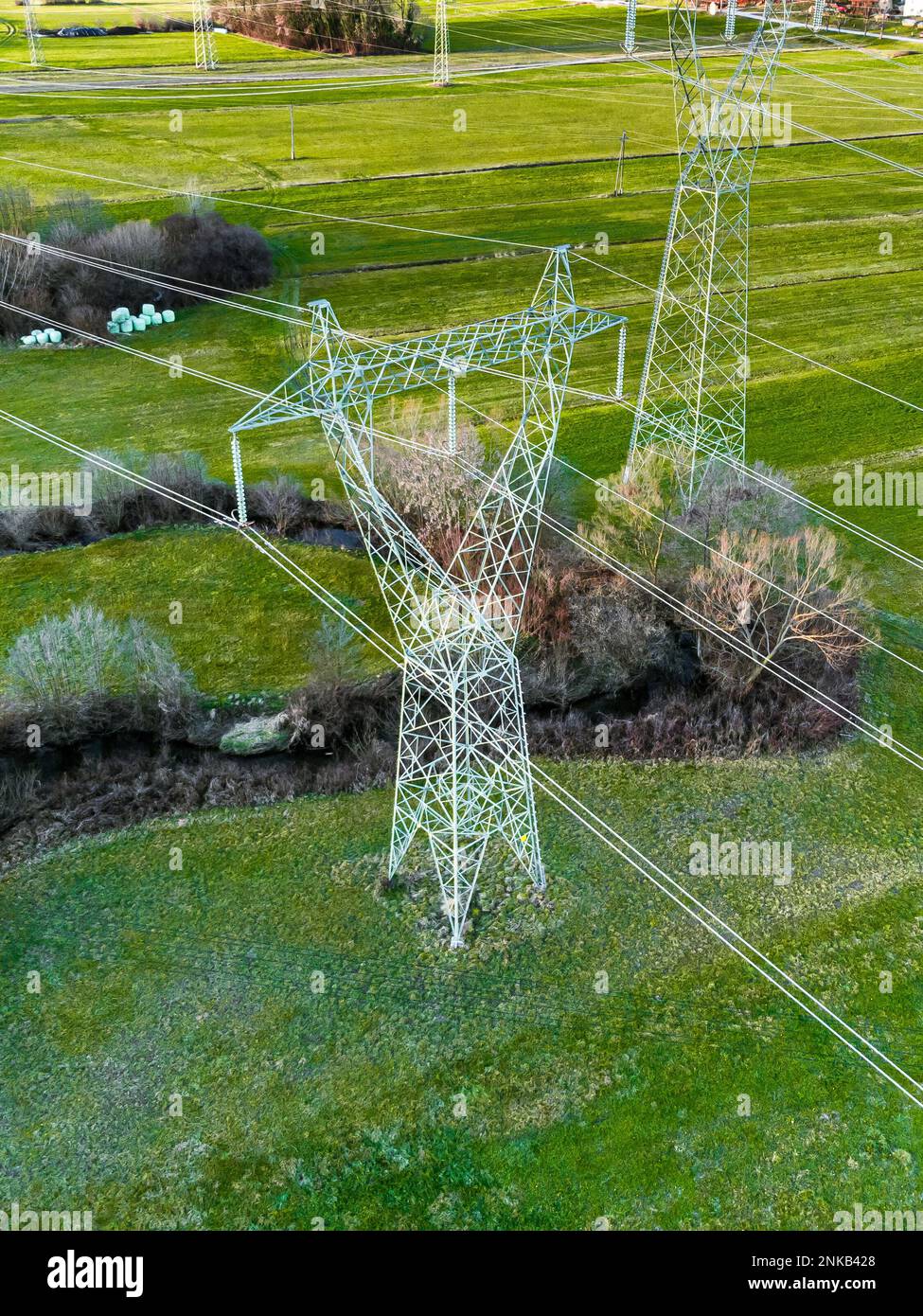 High voltage power transmission towers near a winding creek. Drone ...