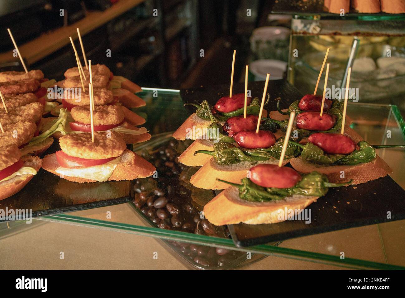 tapas (pintxos, sandwich) with small sausage and salted peppers, bread ...