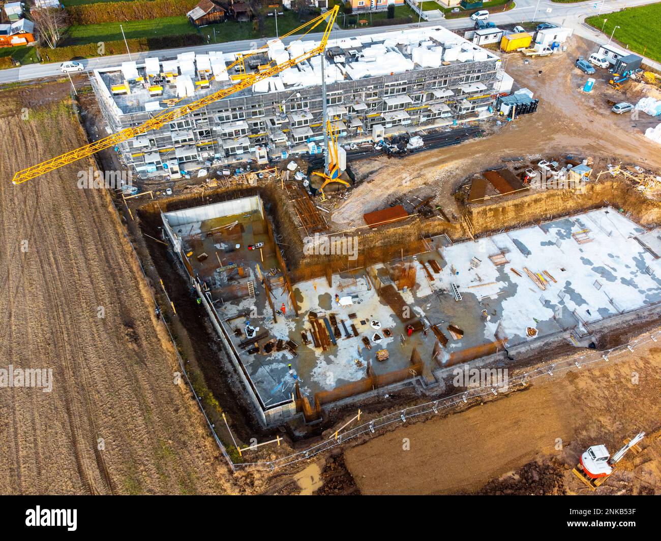 Two new apartment buildings under construction, one almost finished, and other having concrete ...