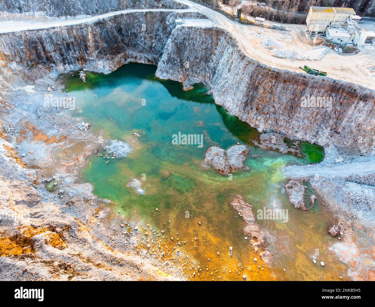 Open stone quarry pit filled with green algae water aerial view Stock ...