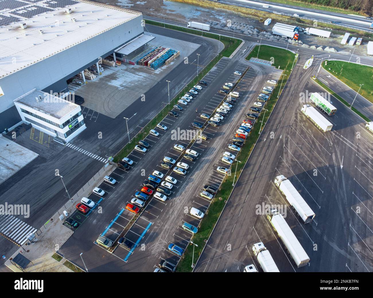 Aerial view of a factory and factory parking lot with cars and trucks ...