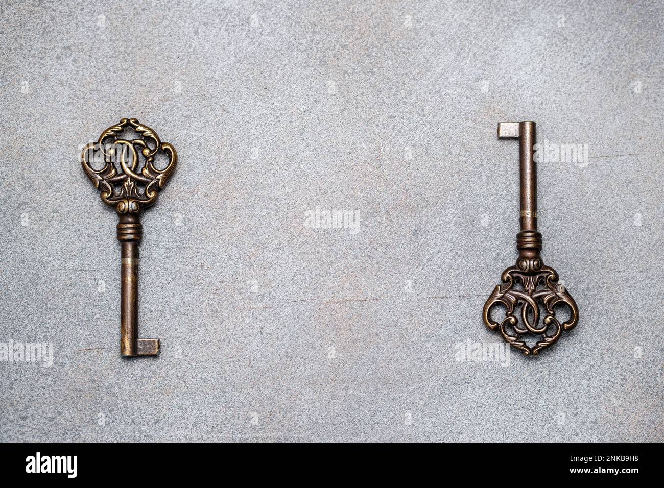 Two old vintage bronze keys on an abstract gray background. View from ...