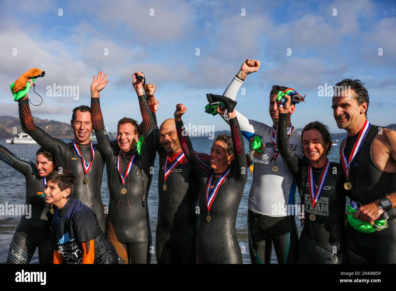 People cheer as they pose for a photograph after completing the fifth ...