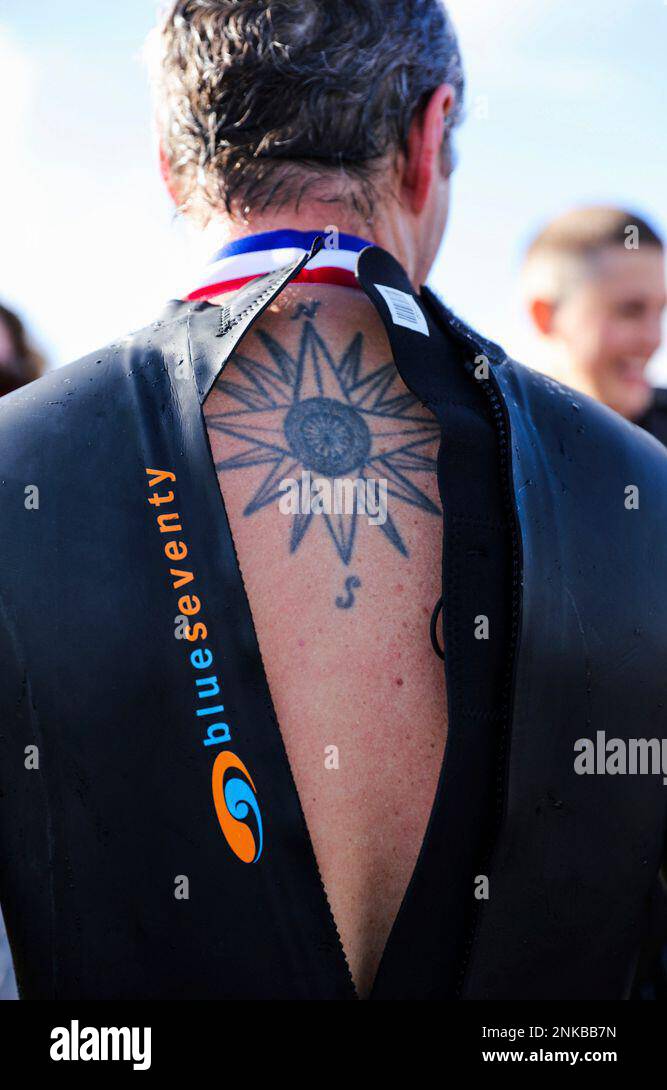 Glenn Heuser's tattoo is seen through his unzipped wetsuit after he ...