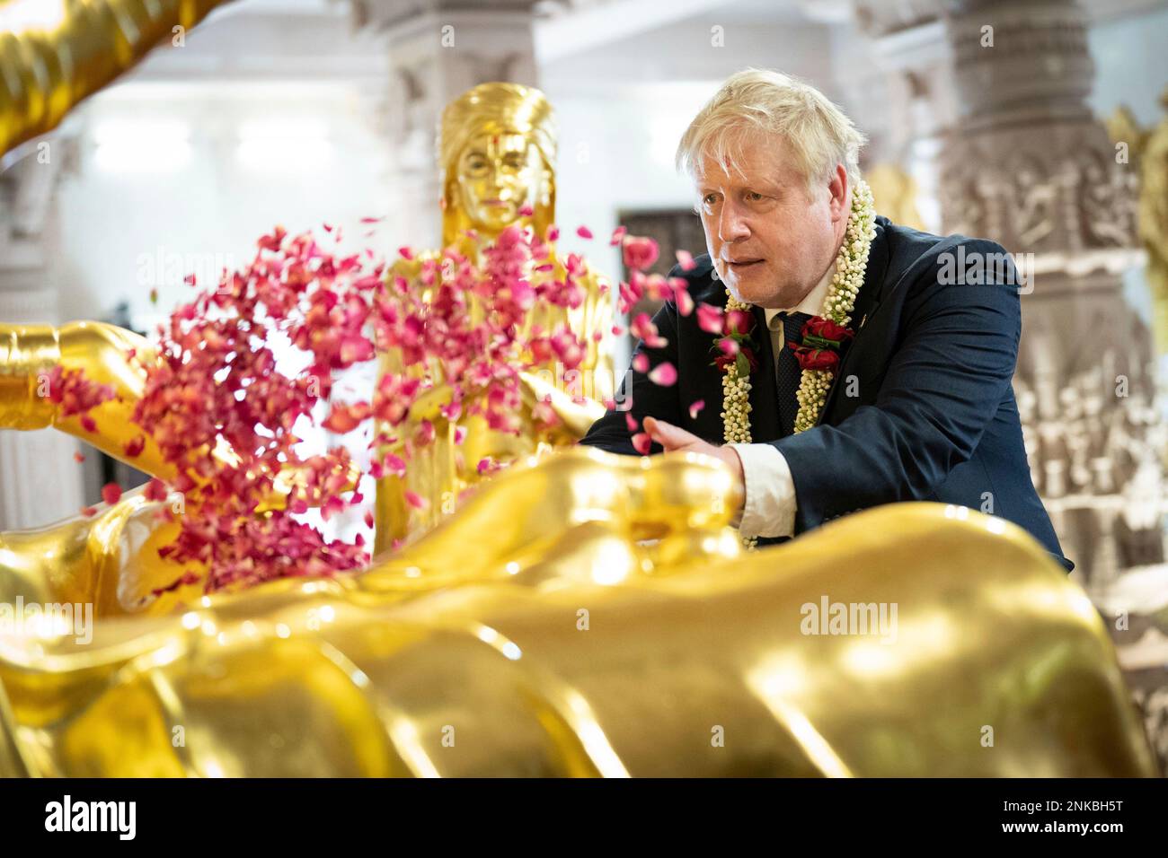 British Prime Minister Boris Johnson throws petals at a shrine as he ...