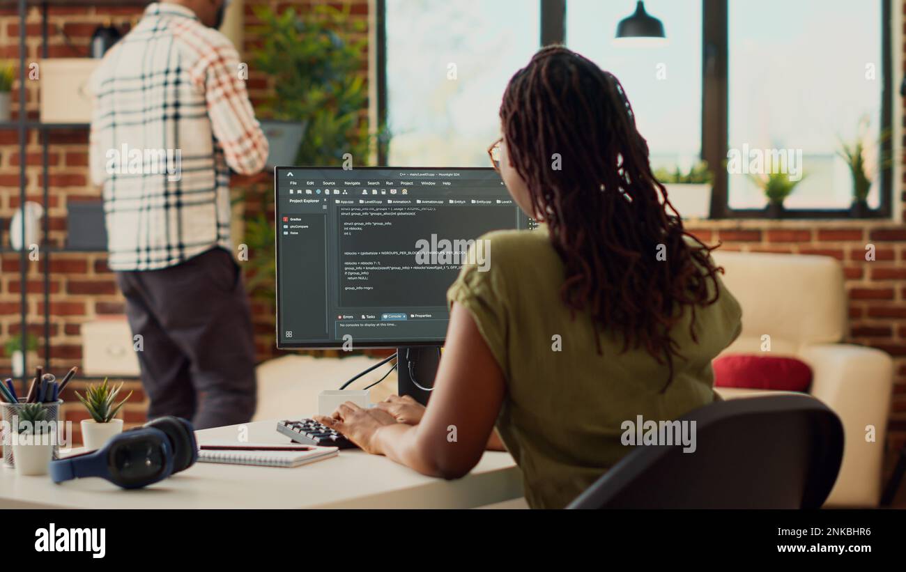Young woman using source code to develop new online app, working with ...