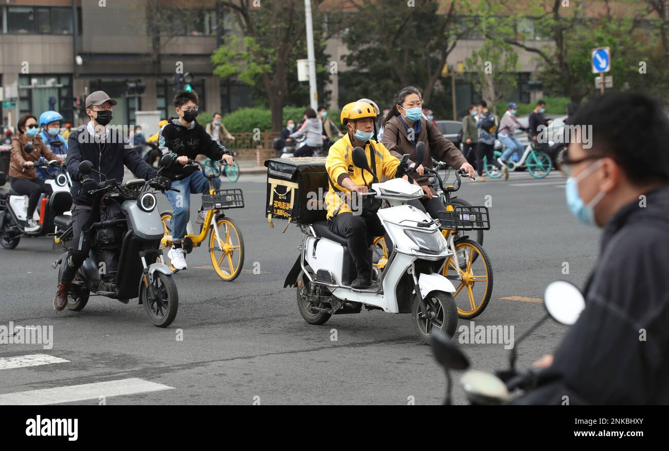 A staff of Meituan (yellow jacket) rides a bike in Beijing, China on ...