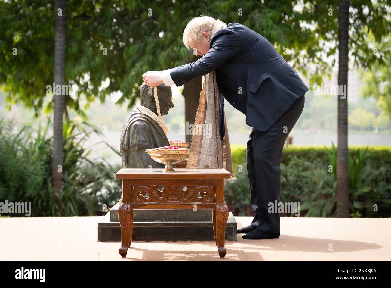 British Prime Minister Boris Johnson places a garland around the neck ...