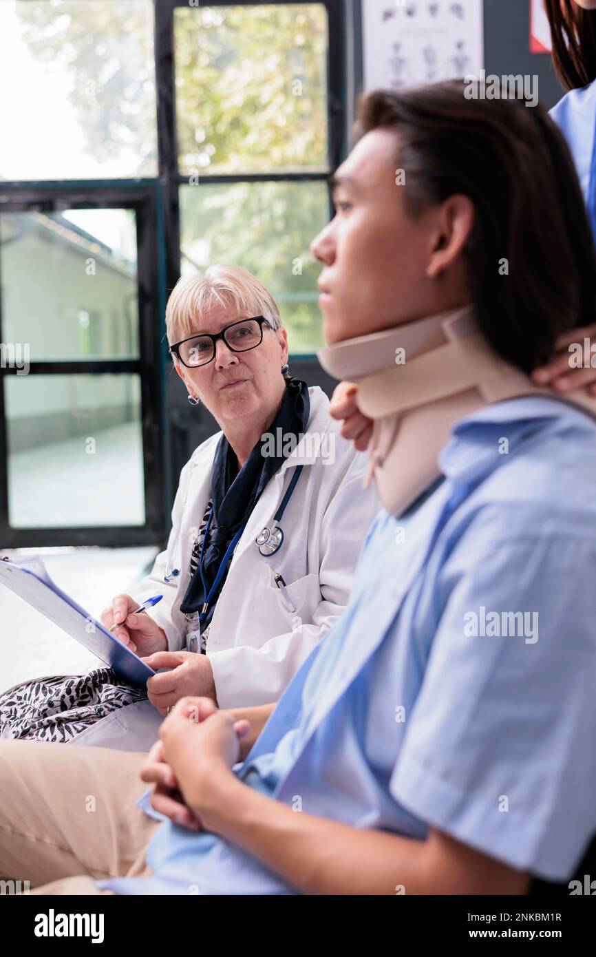 Nurse and medic helping asian patient with neck brace removing cervical ...