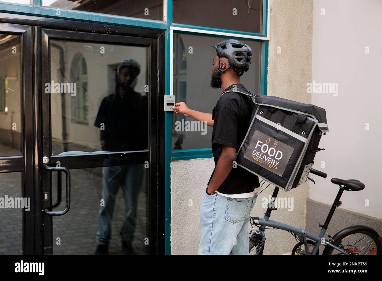 Food delivery service courier ringing office building doorbell, waiting ...