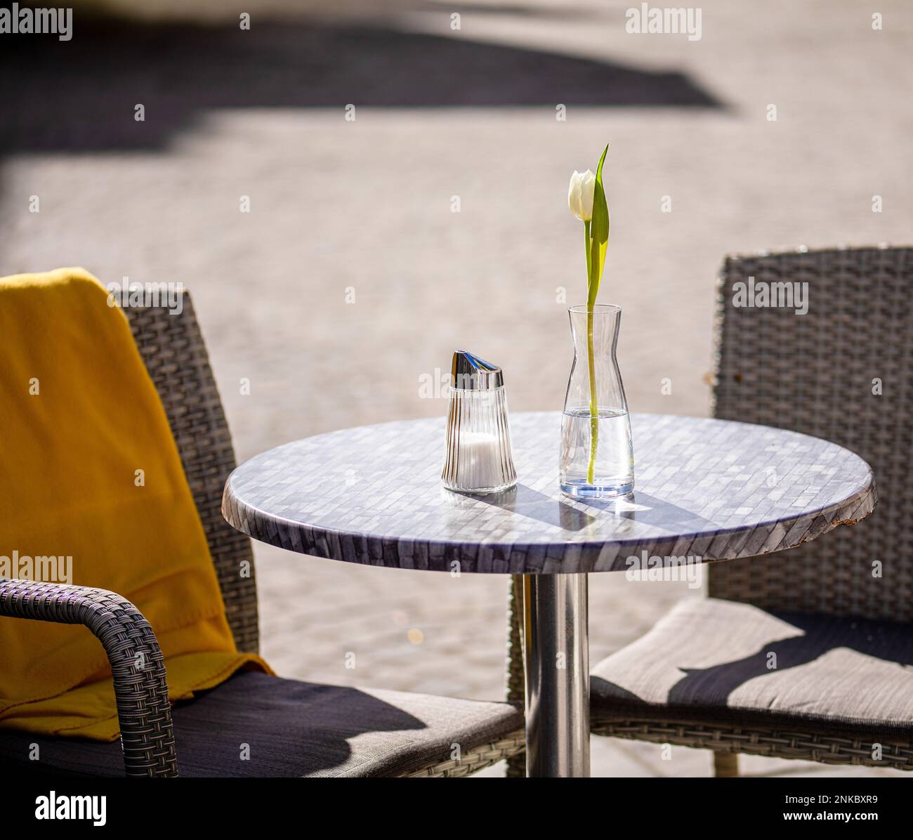 Empty tables outside between lunch hours along a cobblestone alley in a ...