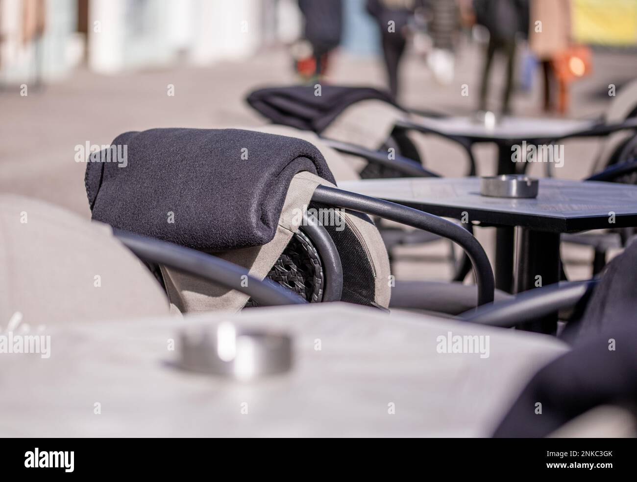 Empty tables outside between lunch hours along a cobblestone alley in a ...