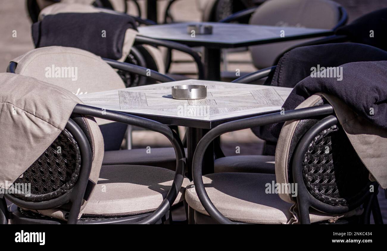 Empty tables outside between lunch hours along a cobblestone alley in a ...